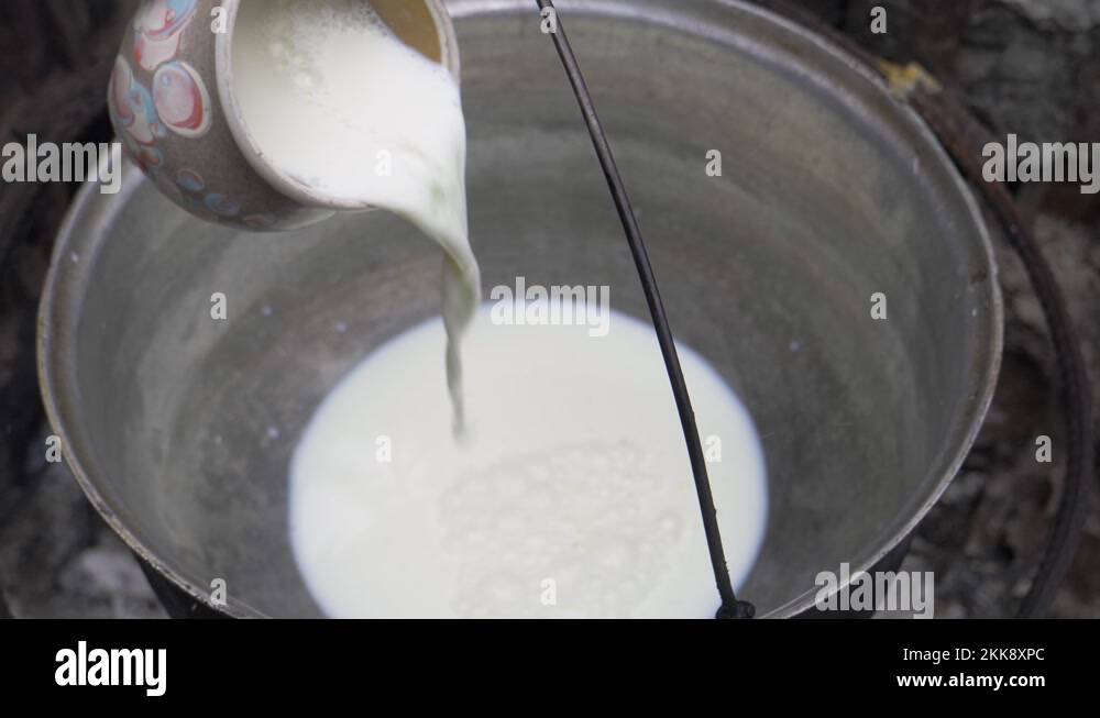 Cup of milk poured into a black cauldron and set on fire. The cup is ...