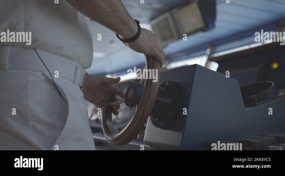 close-up of captain's hands on the wheel in a cruise ship driving ship ...