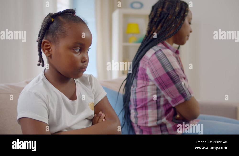 Young african mother and small daughter avoid talking after ...