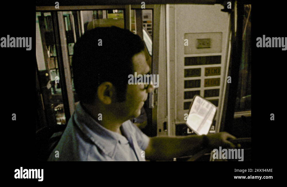 1970s: Bus driver pays woman at toll booth. Traffic comes out of tunnel ...