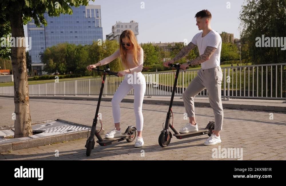 Portrait of a young couple in love in the Park on electric scooters in summer Stock Video ...