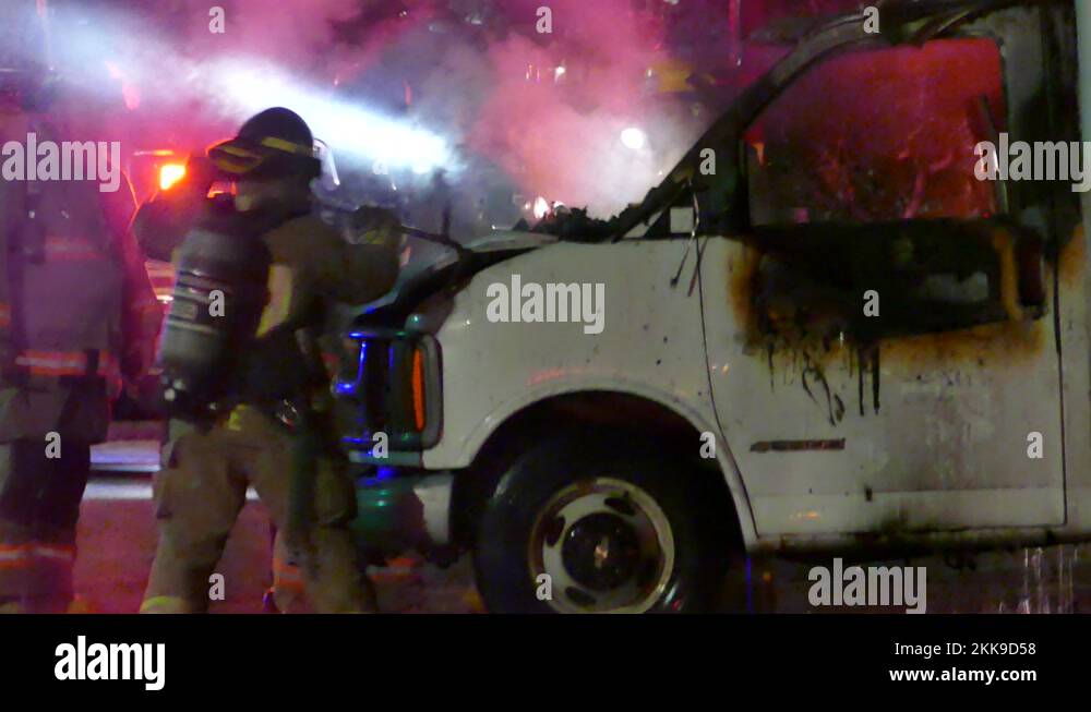 Firefighters trying to extinguish fire inside engine compartment of ...