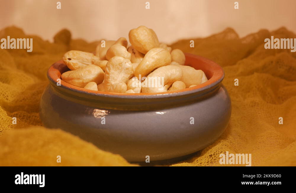 Cashew nuts are rotated in a clay pot. Rotation. Healthy food for a ...