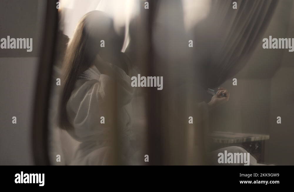 Reflection in mirror of gorgeous slim rich woman combing hair in the morning in Stock Video ...