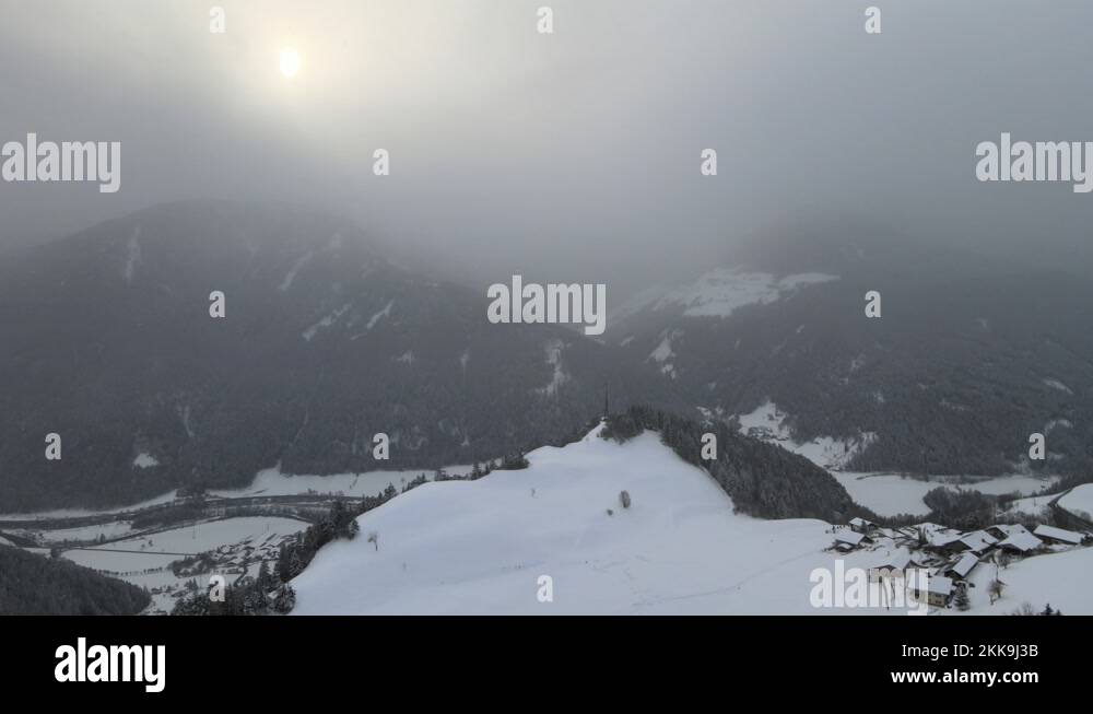 dark moody snow storm in the italian alps, you can see a cold valley ...