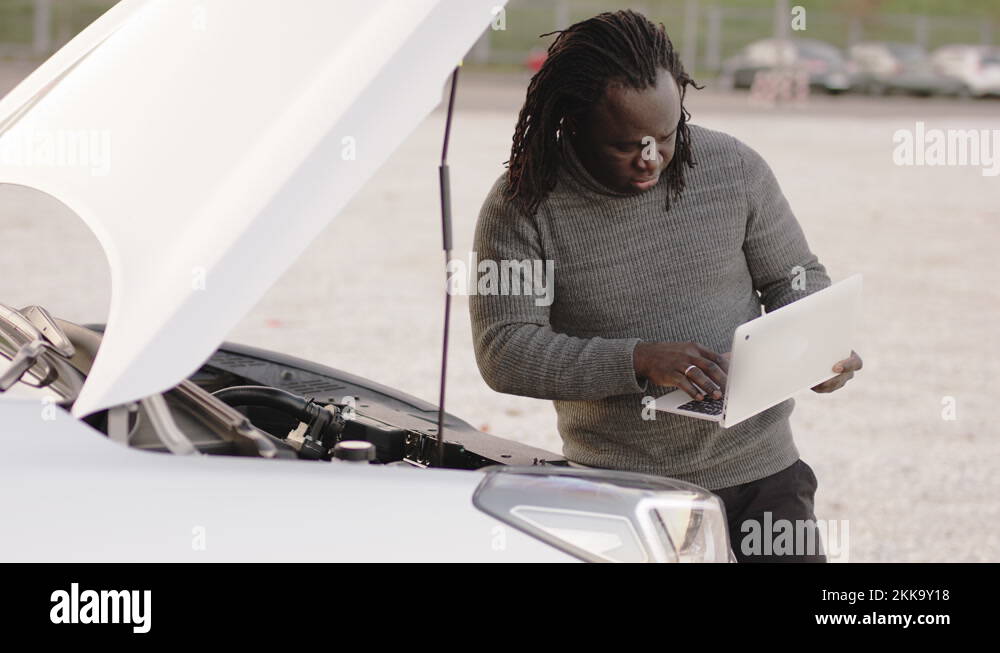 African american black man repairing car while running diagnostics on ...