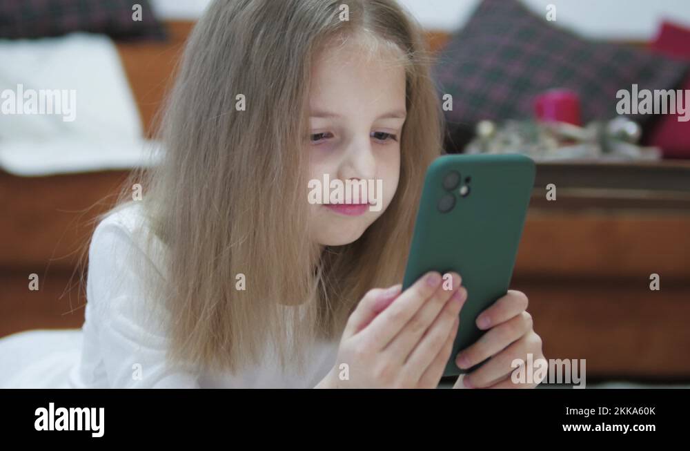 Girl playing mobile game on smartphone. Preschooler kid using mobile ...