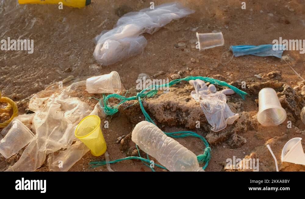 Disposable face masks and plastic debris on the beach in surf zone ...