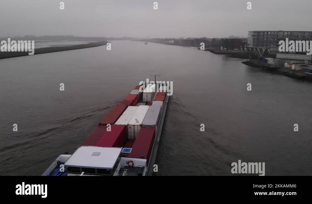 Cargo Ship With Intermodal Containers Crossing On Noord River On A ...