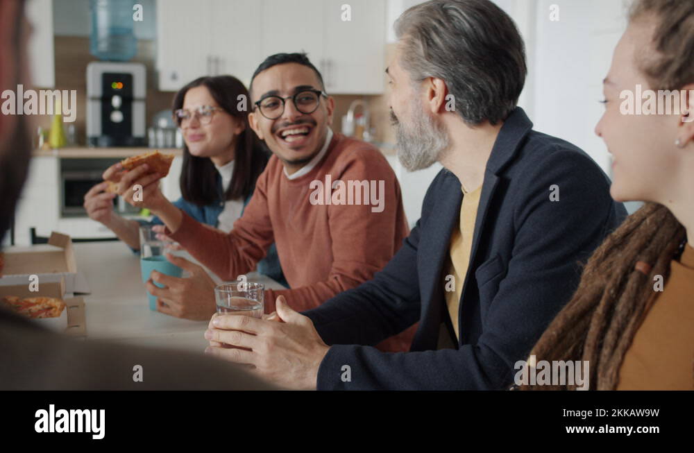 Diverse Group Of People Coworkers Talking And Laughing Eating Pizza In