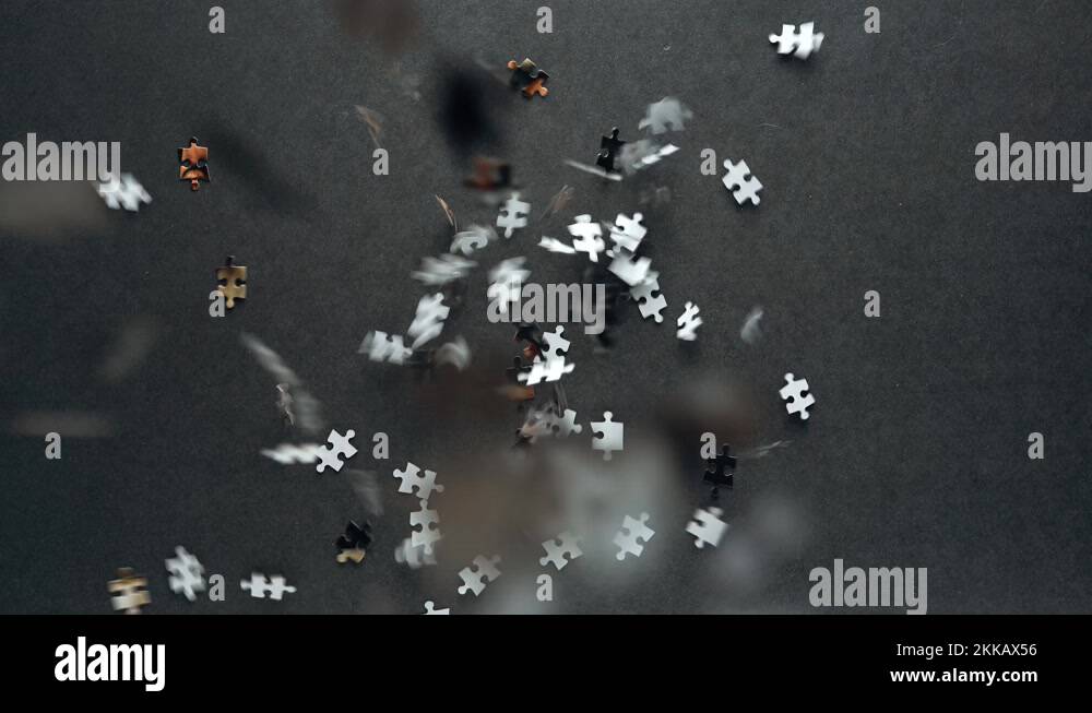 jigsaw puzzle pieces falling down onto gray table top down perspective ...