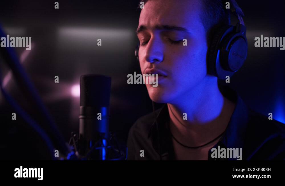 Singer records his composition in a music studio. Young Boy sings a ...