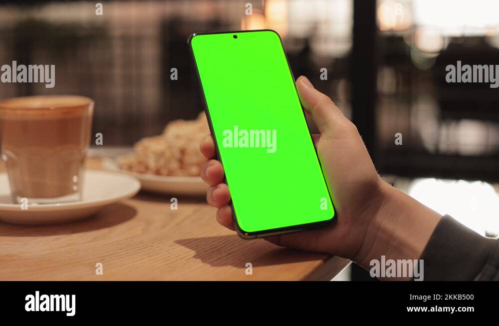 Closeup of Womans Hand is Holding Chroma Key Green Screen in horizontal ...