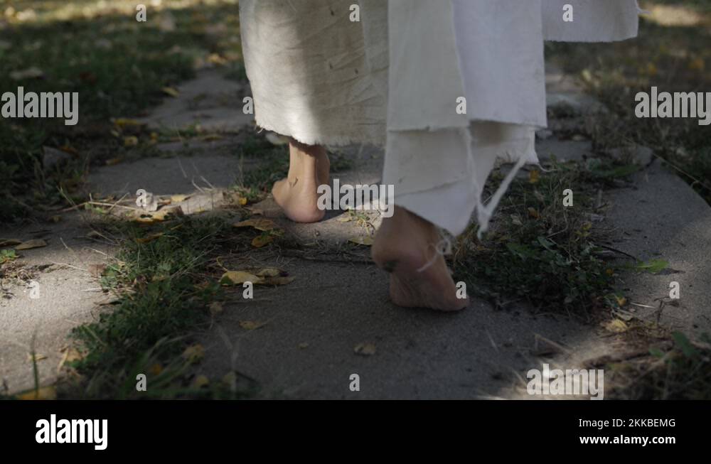 A dramatic slow motion closeup of Jesus wearing a white, tattered robe ...
