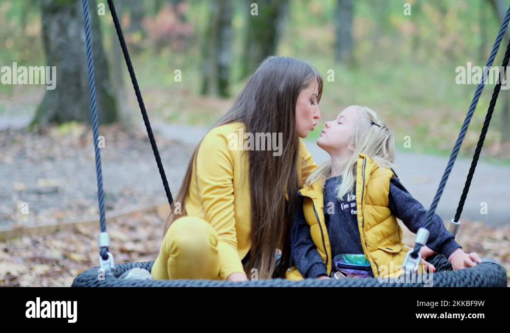 mom and daughter have fun together. young woman and little girl swing on a swing Stock Video ...