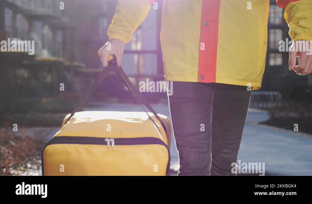 Delivery man walking on the street holding backpack carrying food pizza ...