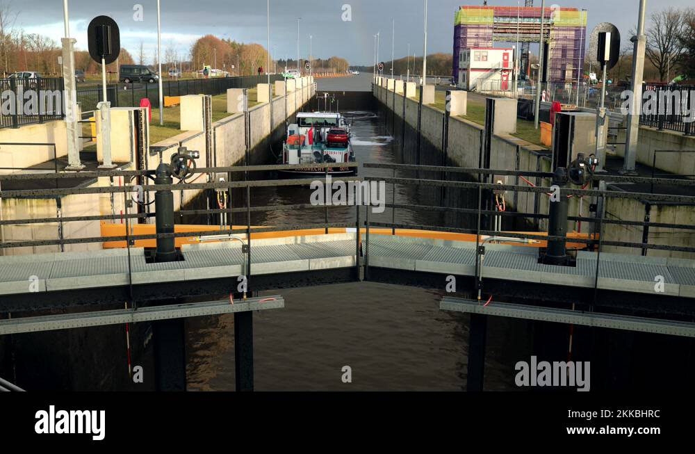 Cargo ship entering Eefde sluice gate with closing of the doors, water ...