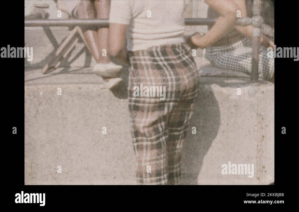 1960s: City street. People visit around stoop. Woman runs away and ...