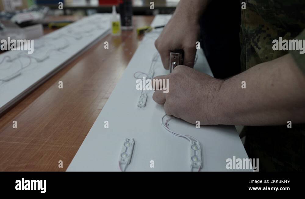 A man installs and attaches an LED light. Installation of LED lighting ...