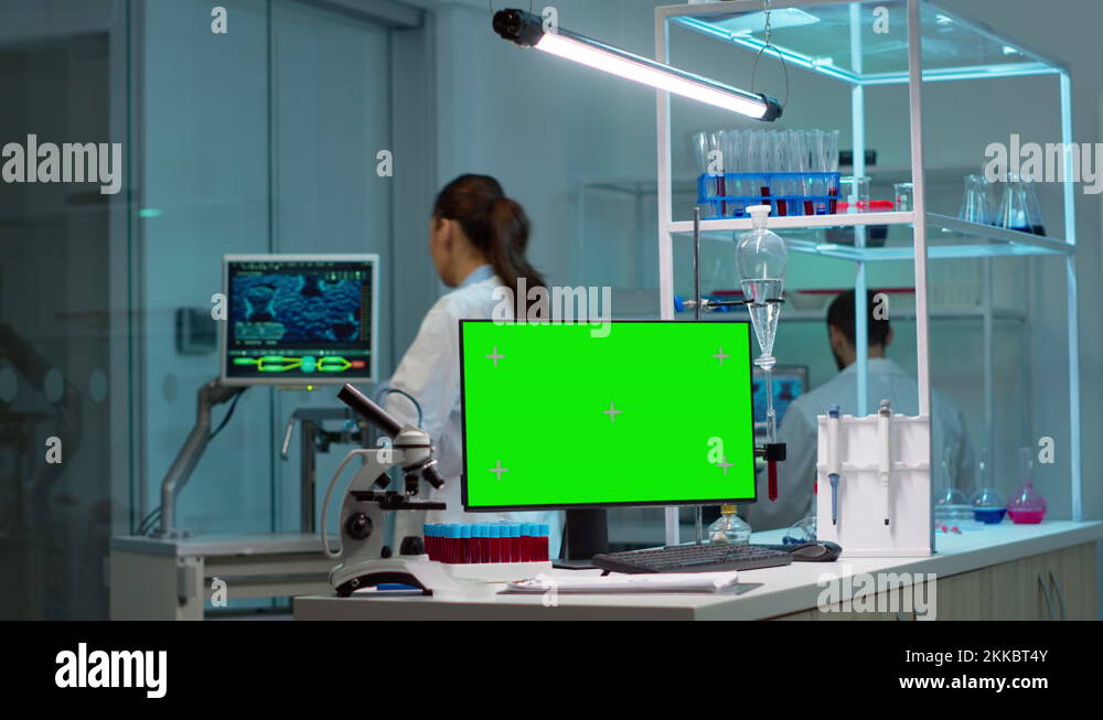 Chemists working in background of lab using pc with green screen Stock ...