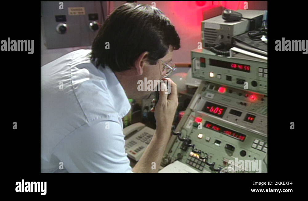 1990s: Missile rocket stands in gantry tower. Engineers and scientists ...