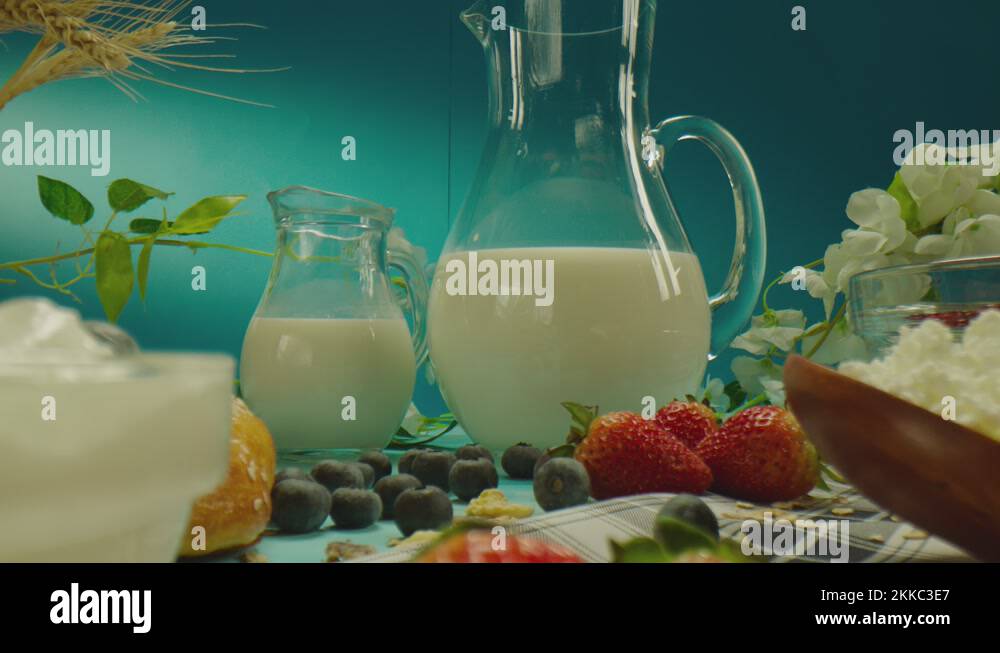 Beautiful decorated table with milk, dairy product, bakery, berries and ...