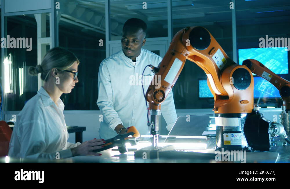 Two science workers are observing industrial robotic arm Stock Video ...
