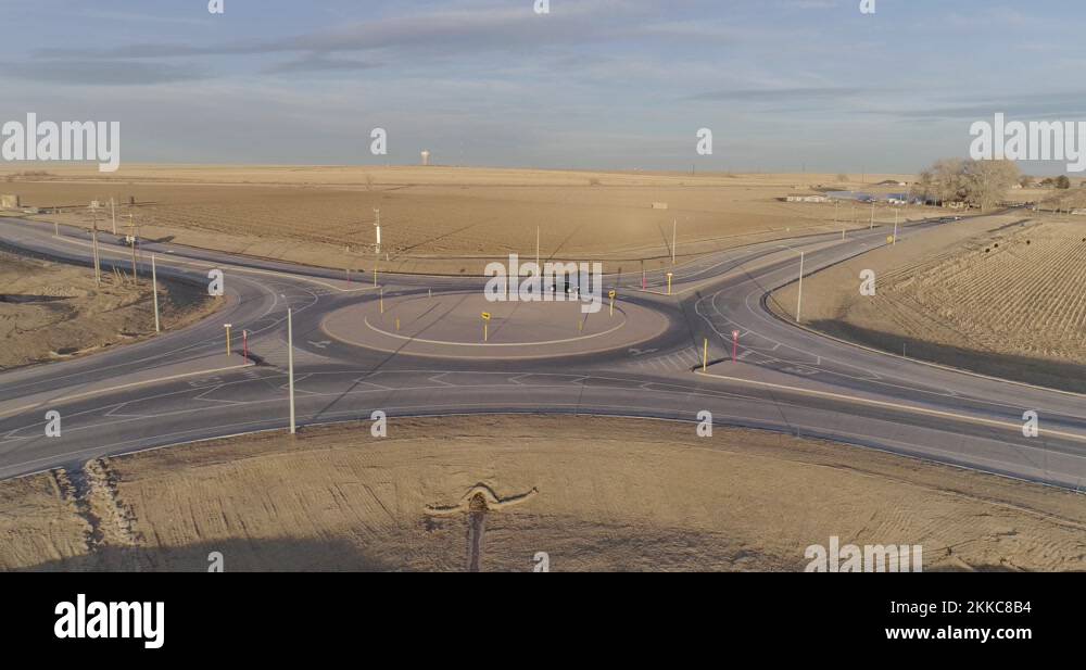 A modern roundabout in the middle of nowhere, Cars navigate a circle ...