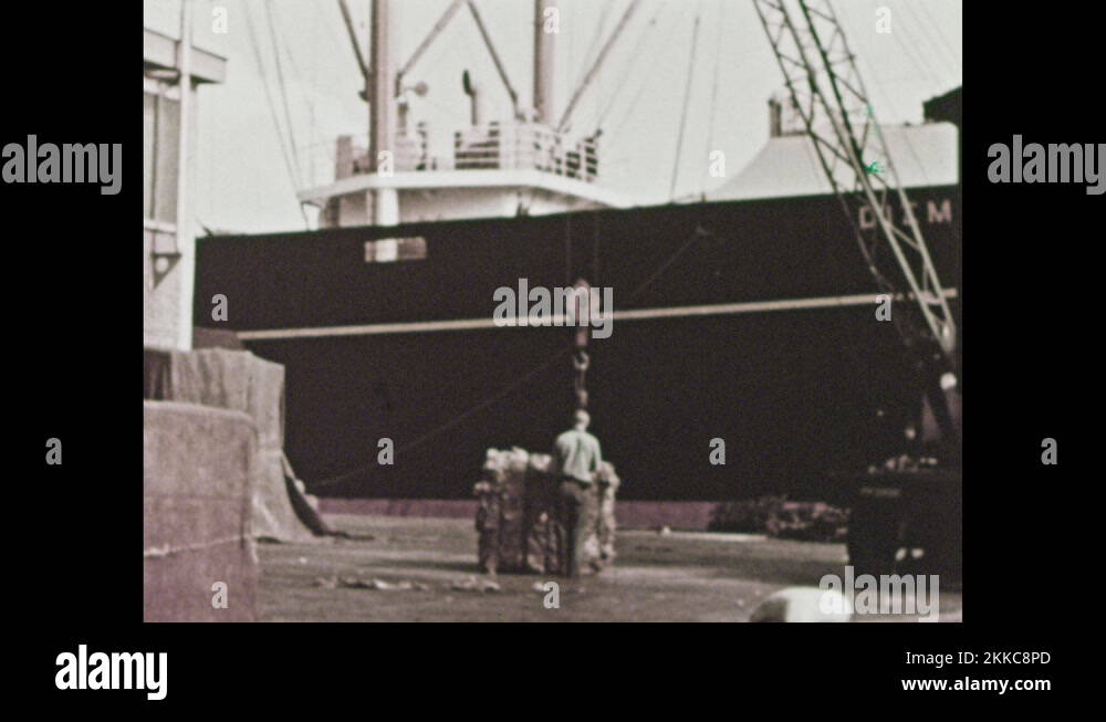 1950s: crane unloading boat at dock, map of Europe, people at outdoor ...