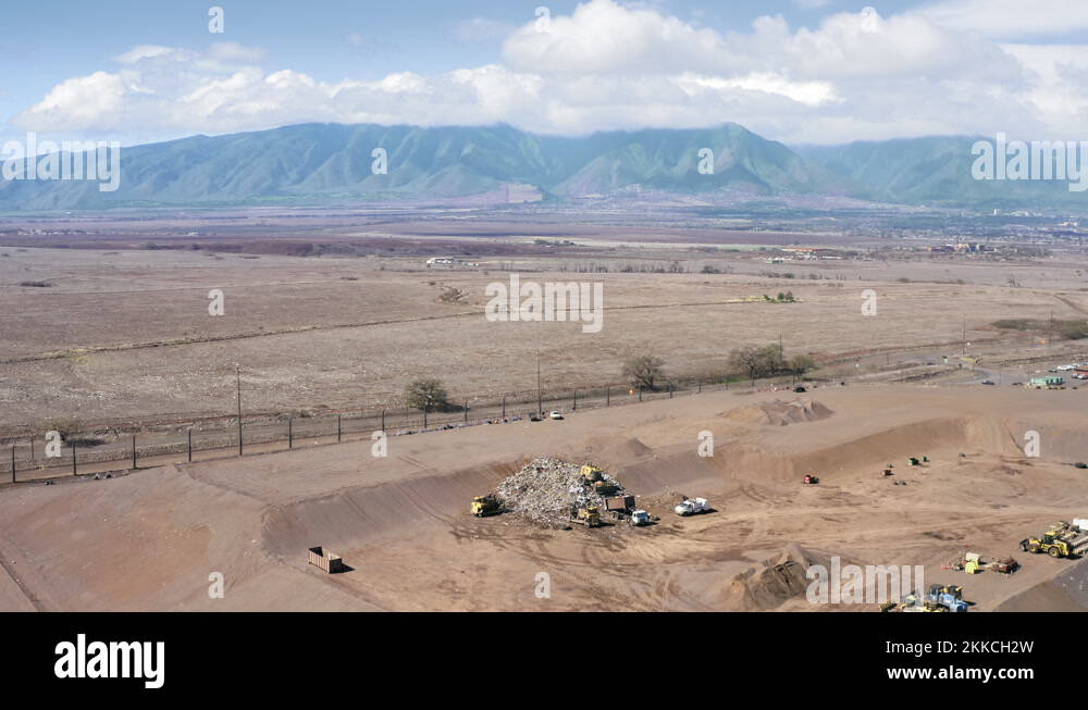 People working on landfill on Hawaii island, USA. Trash trucks leveling ...