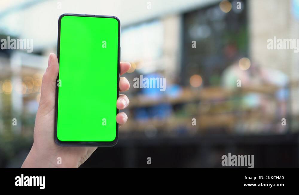 Close up hands woman holding phone with vertical green screen on busy street Stock Video Footage ...