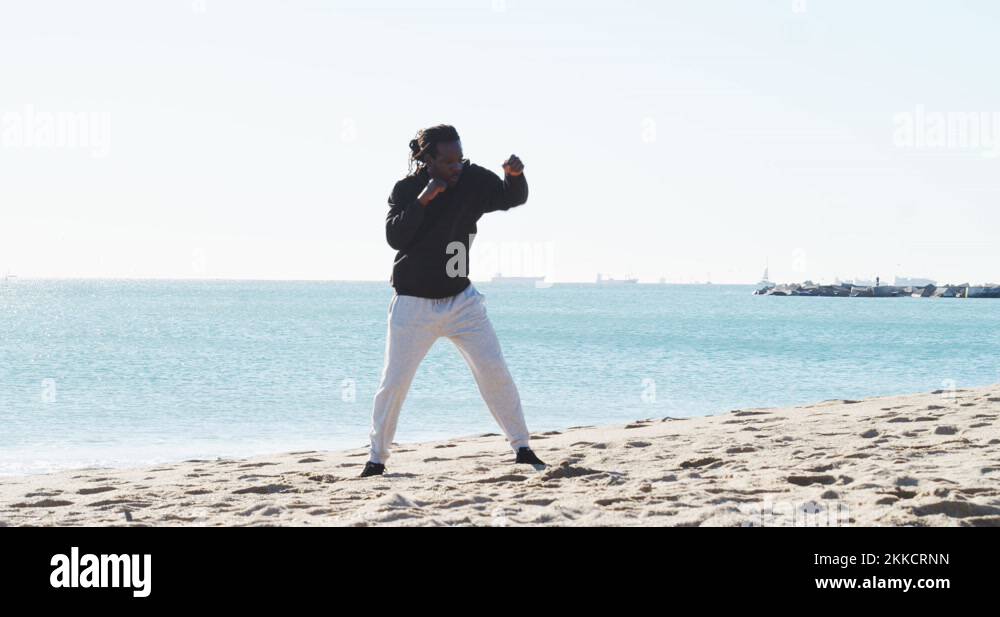 Afro fighter with dreadlocks trains martial arts on the beach Stock ...