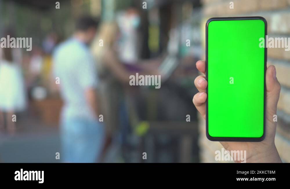 Close up hands woman holding phone with vertical green screen on busy street Stock Video Footage ...