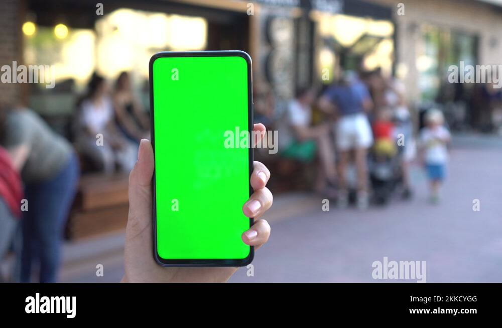 Close up hands woman holding phone with vertical green screen on busy street Stock Video Footage ...