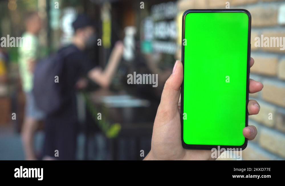 Close up hands woman holding phone with vertical green screen on busy street Stock Video Footage ...