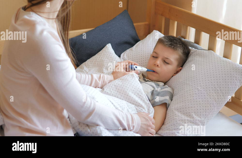 Mother measuring temperature of her ill kid. Sick child with high fever lying at Stock Video ...
