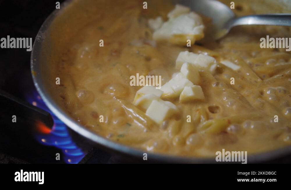 Cheese Falls On Pasta Sauce Boiling On Pan Over Medium Fire In Kitchen ...