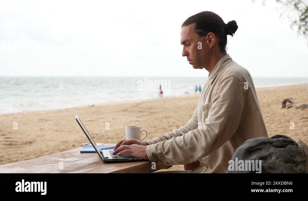 Man work hard, fixed to laptop, sit by remote workplace on tropical ...