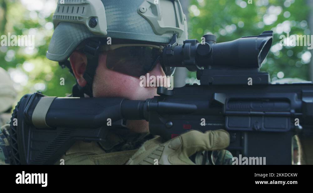 Close up of solider using assault rifle while protecting military base ...