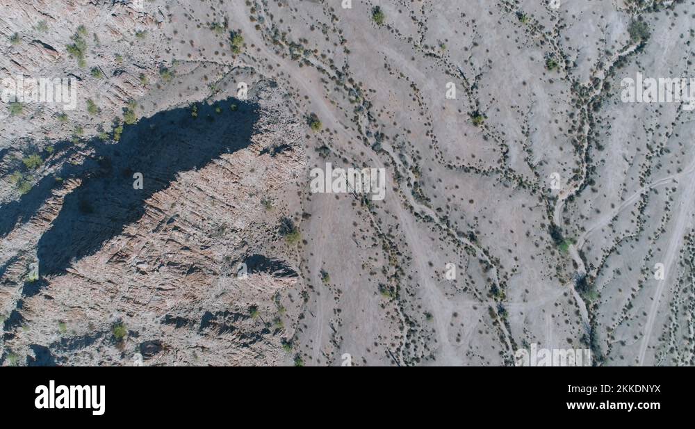 Top down aerial flight over rocky hill and gully erosion in harsh ...