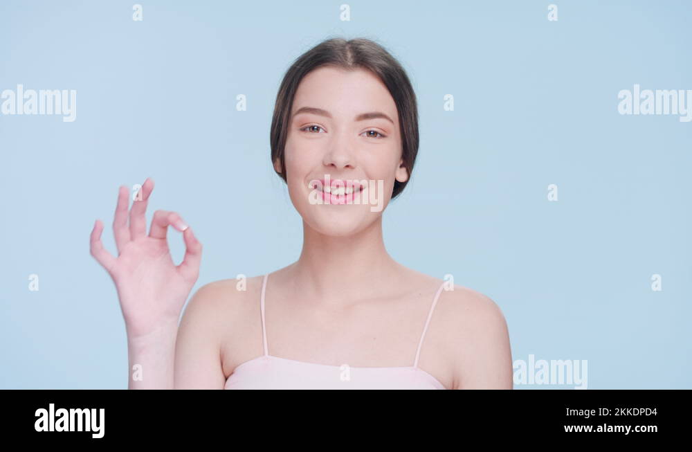 Young brunette woman looks at camera and makes an ok hand sign Stock ...