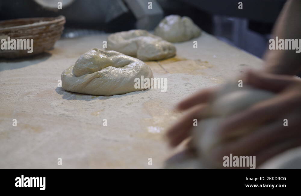 Baker's hands form the shapes of bread after the automated equipment at ...