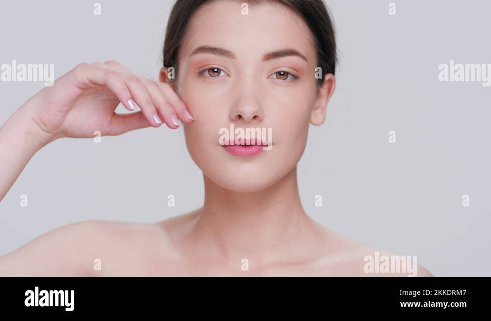 Young woman touches her face sliding hand along her cheek Stock Video ...