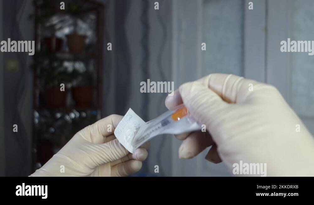 Doctor opens sterile syringe packaging for medical injection. Treating ...