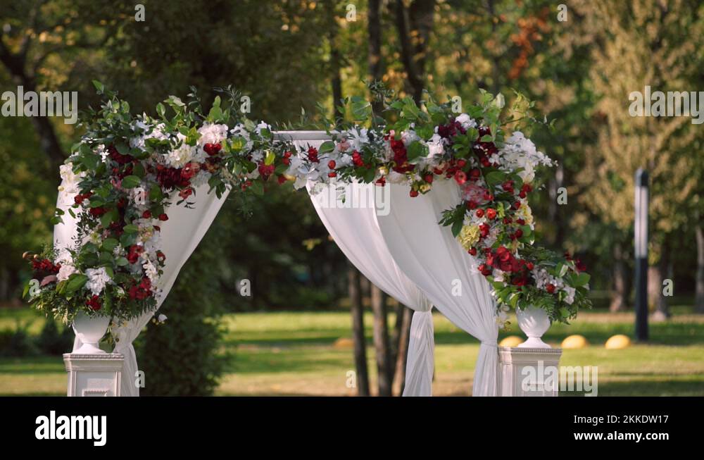 Close-up wedding arch with columns, decorated with vases of flowers ...