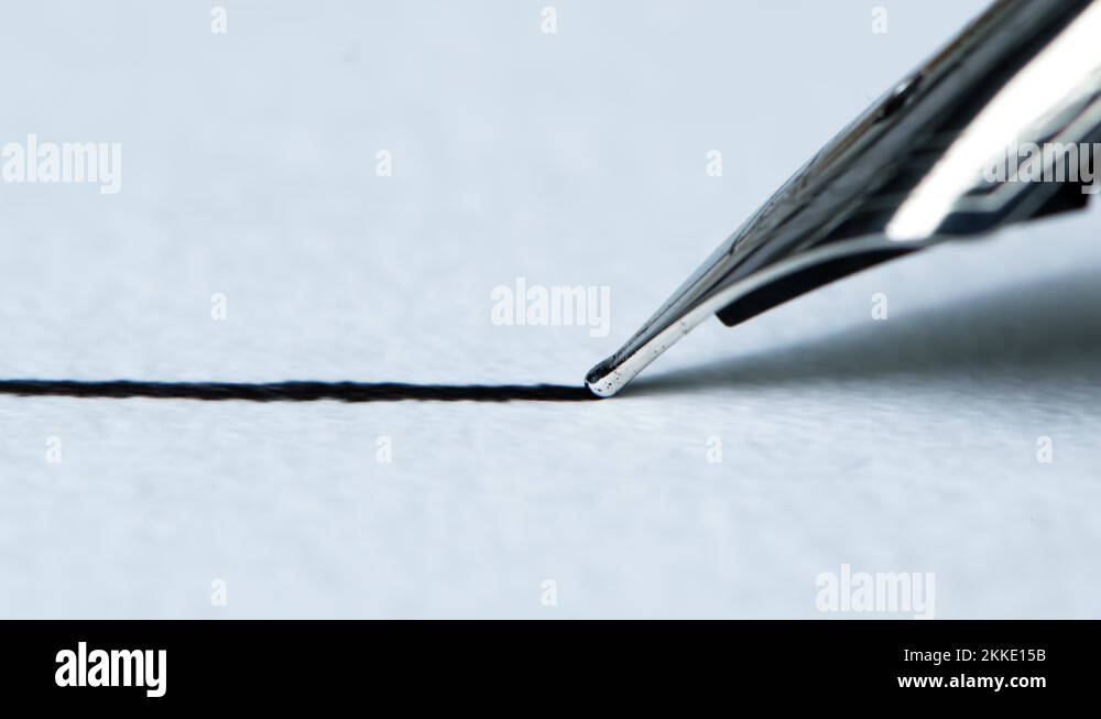 A fountain pen drawing a straight line on a textured paper surface ...