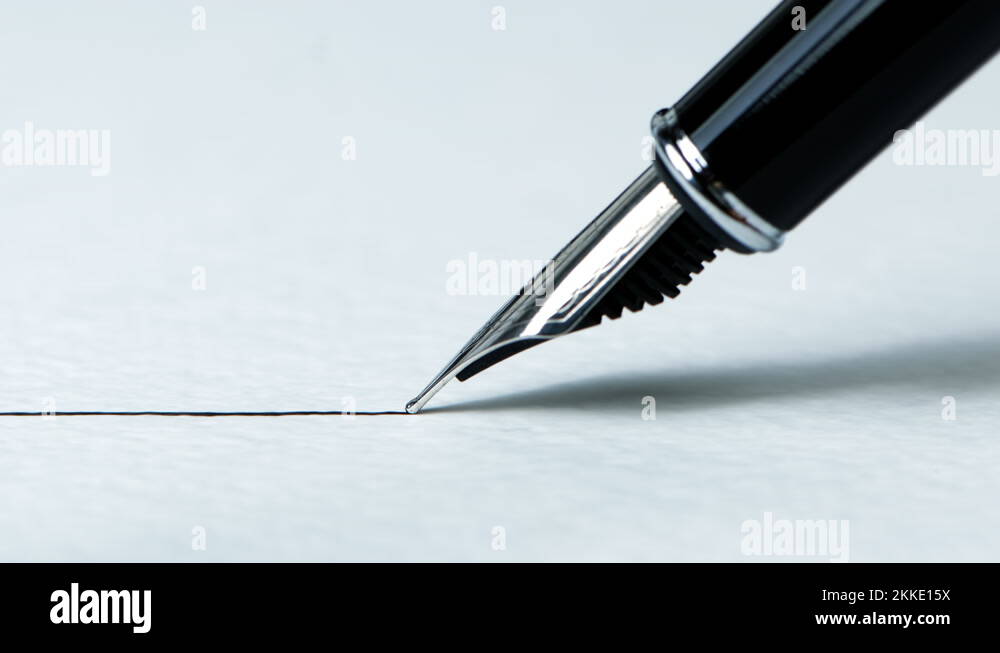 A fountain pen drawing a straight line on a textured paper surface ...