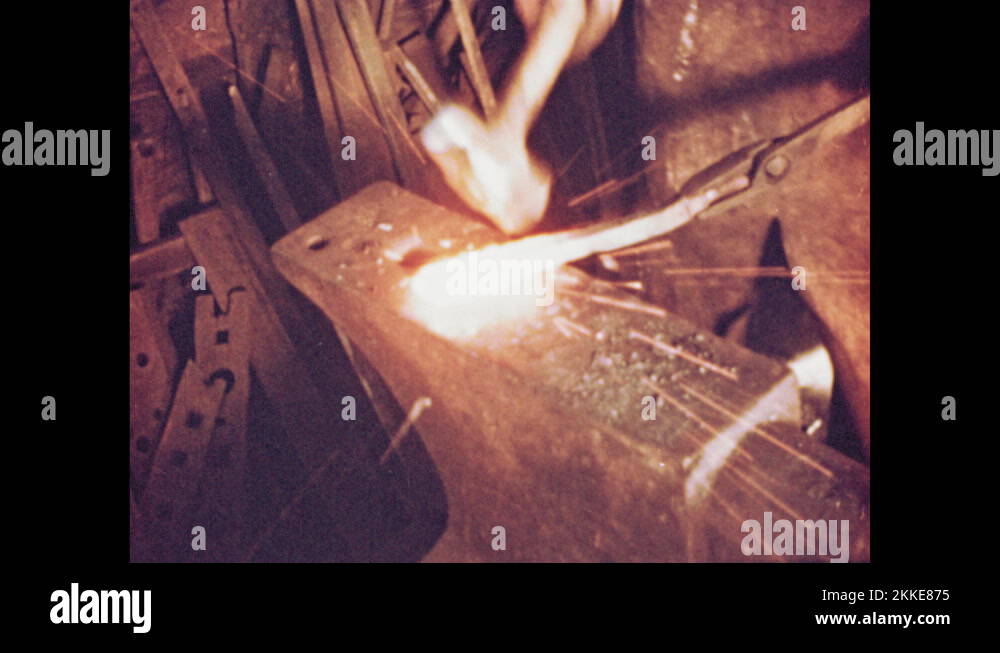 1960s: Iron spear tip held by hands. Blacksmith forges iron tool. Open ...