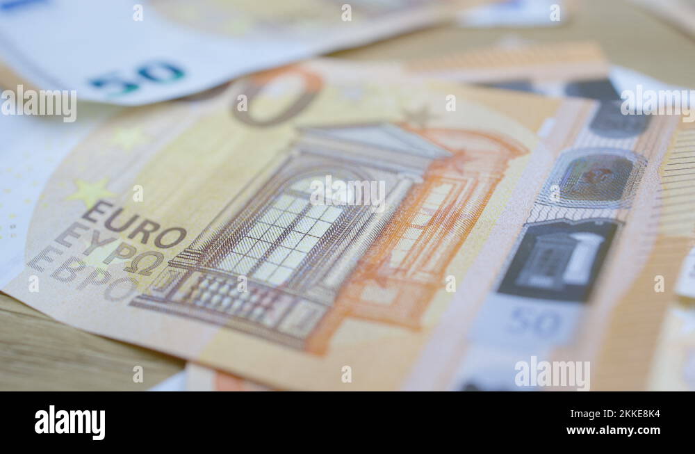 Male Hand borrowing a 50 euro bill, from a pile of money and gives it ...