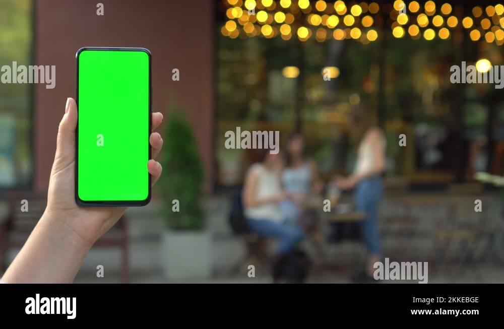Close up hands woman holding phone with vertical green screen on busy street Stock Video Footage ...